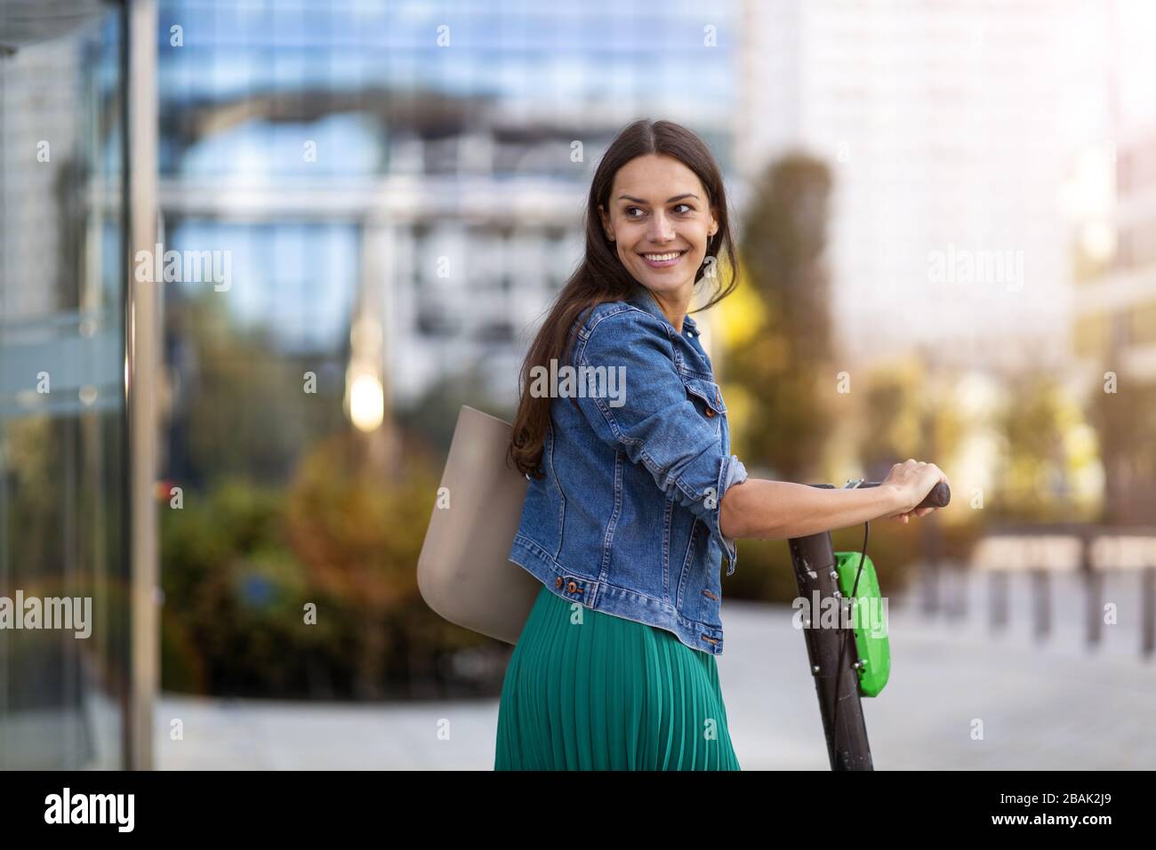 Female commuter riding electric push scooter Stock Photo - Alamy