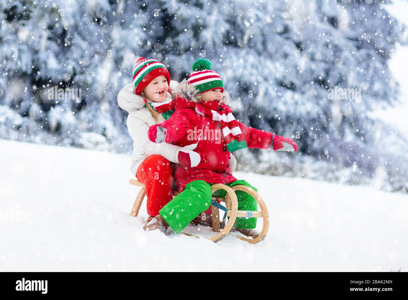 Little girl and boy enjoying sleigh ride. Child sledding. Toddler kid ...