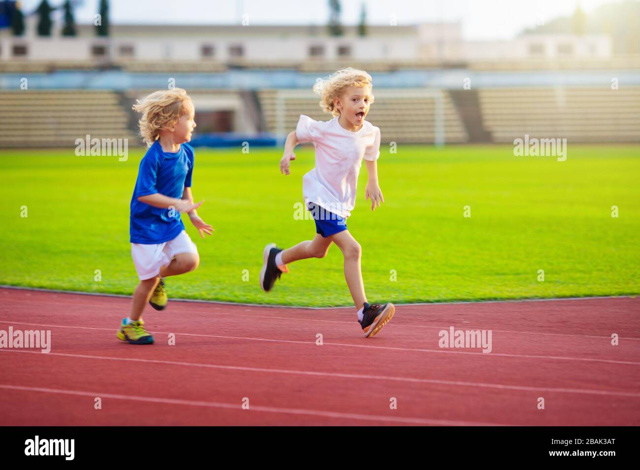Child running in stadium. Kids run on outdoor track. Healthy sport ...