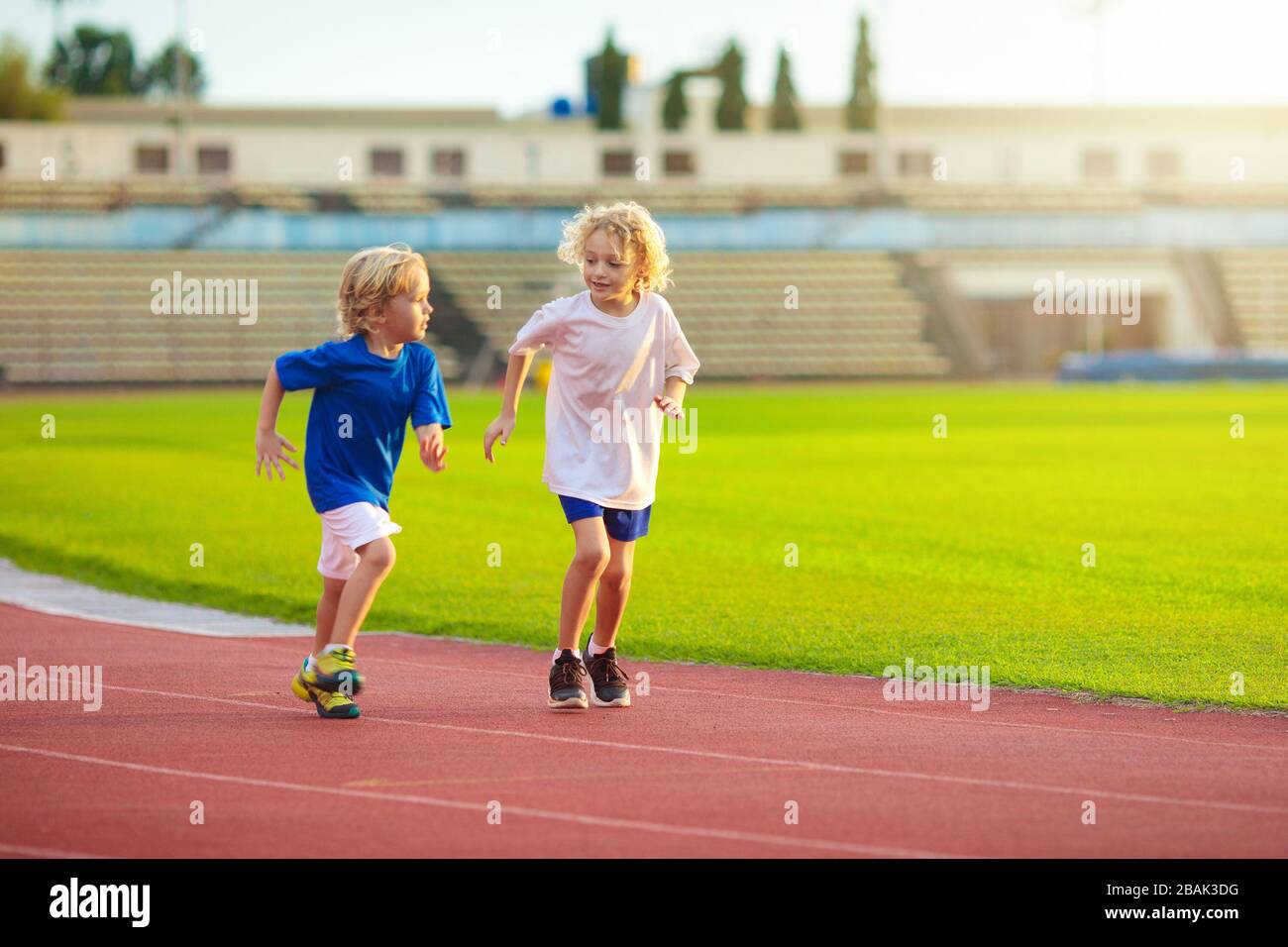 Child running in stadium. Kids run on outdoor track. Healthy sport ...