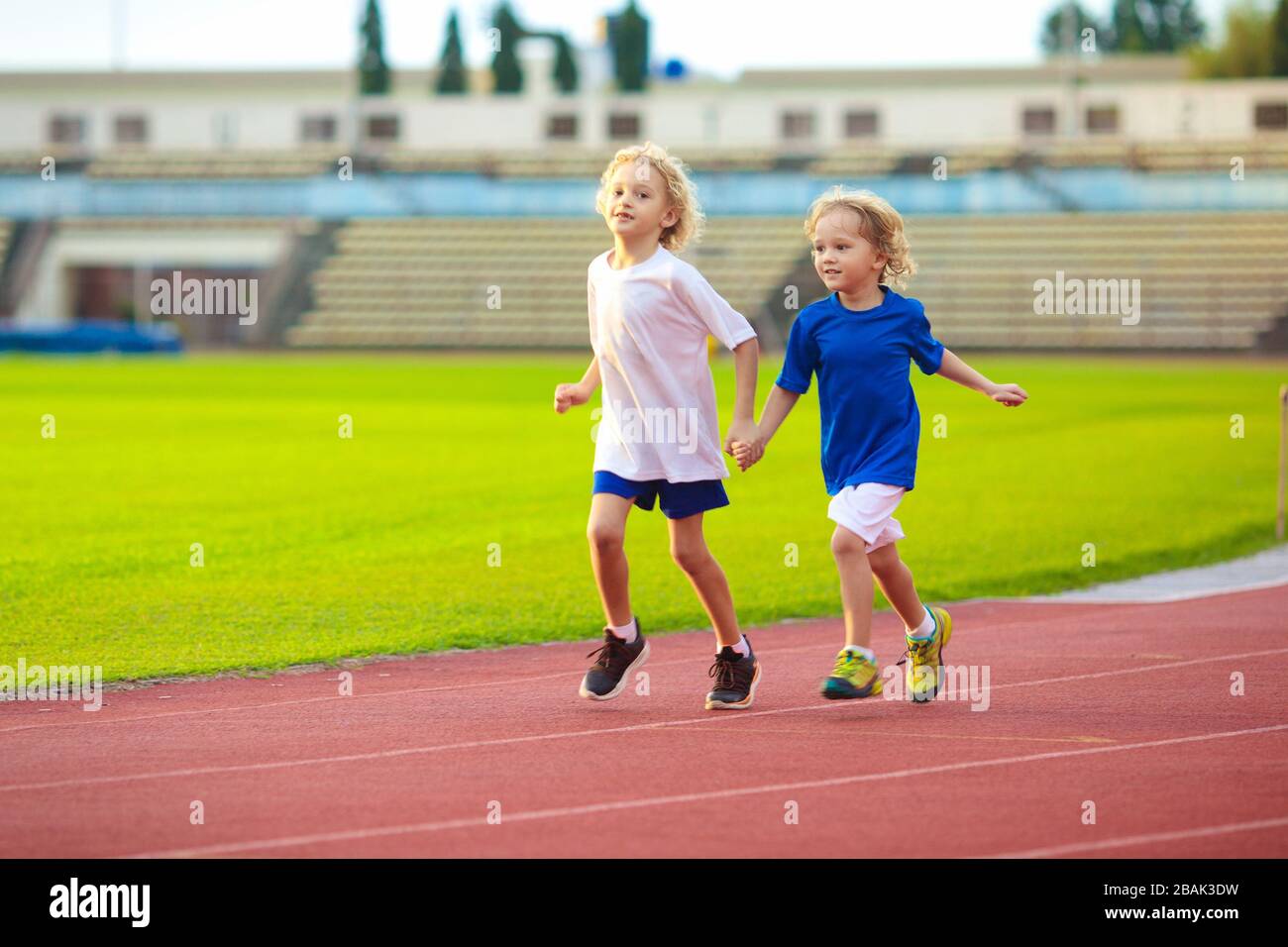 Child running in stadium. Kids run on outdoor track. Healthy sport ...