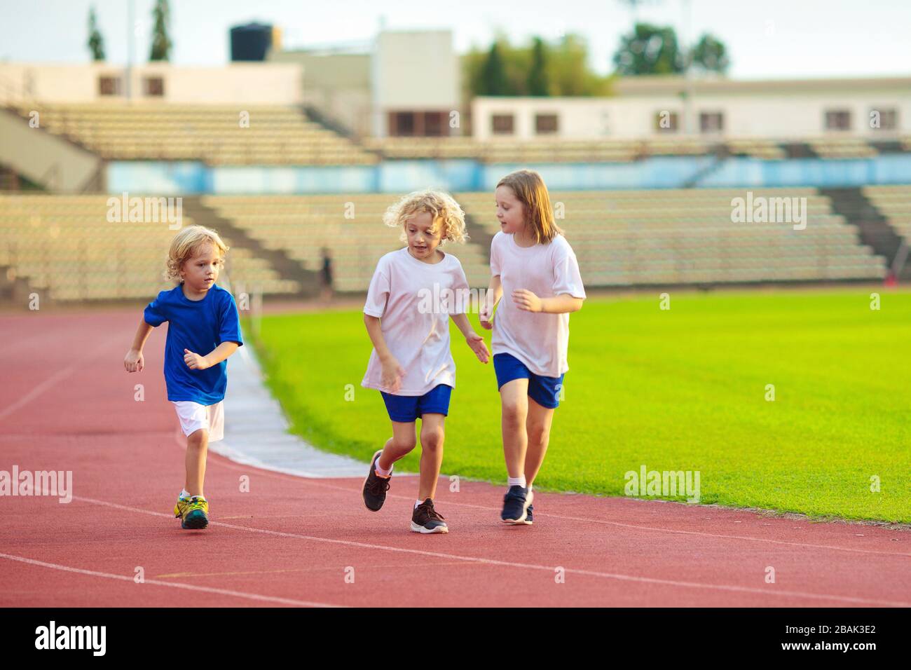 Child running in stadium. Kids run on outdoor track. Healthy sport ...