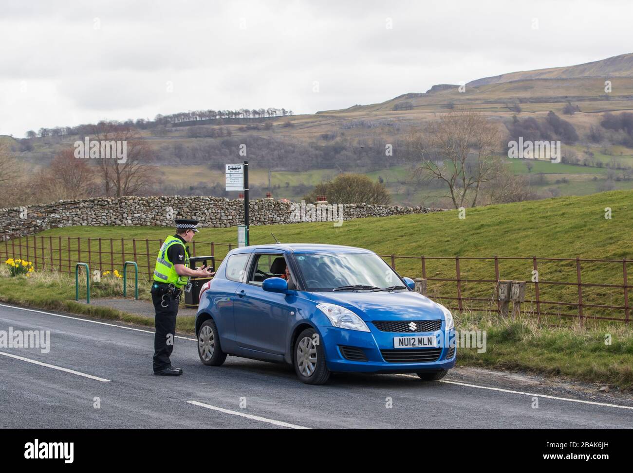 A policeman stops a car at a vehicle check point in Aysgarth in North ...