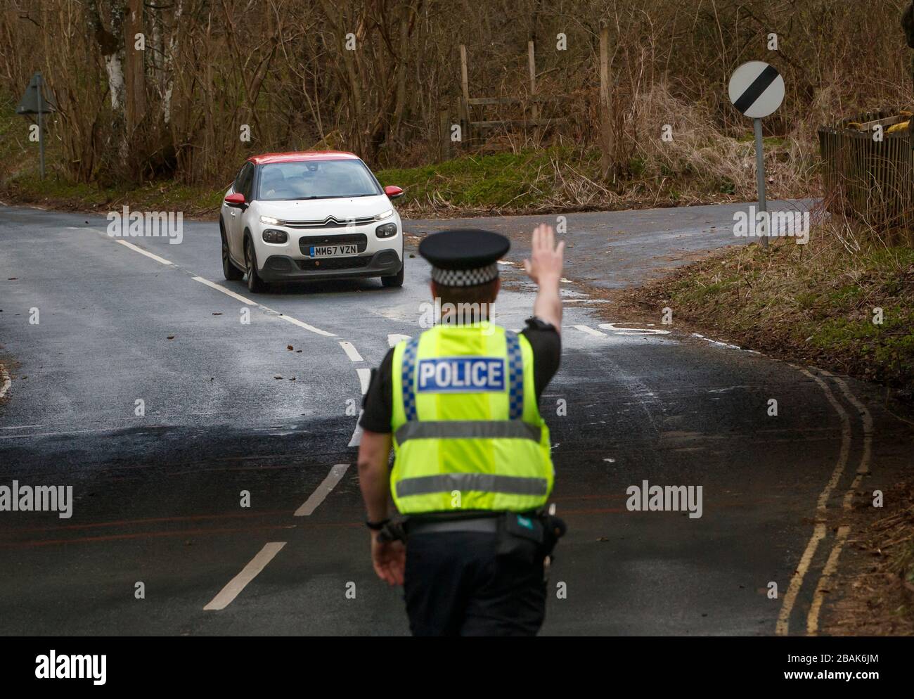 A policeman stops a car at a vehicle check point in Aysgarth in North ...