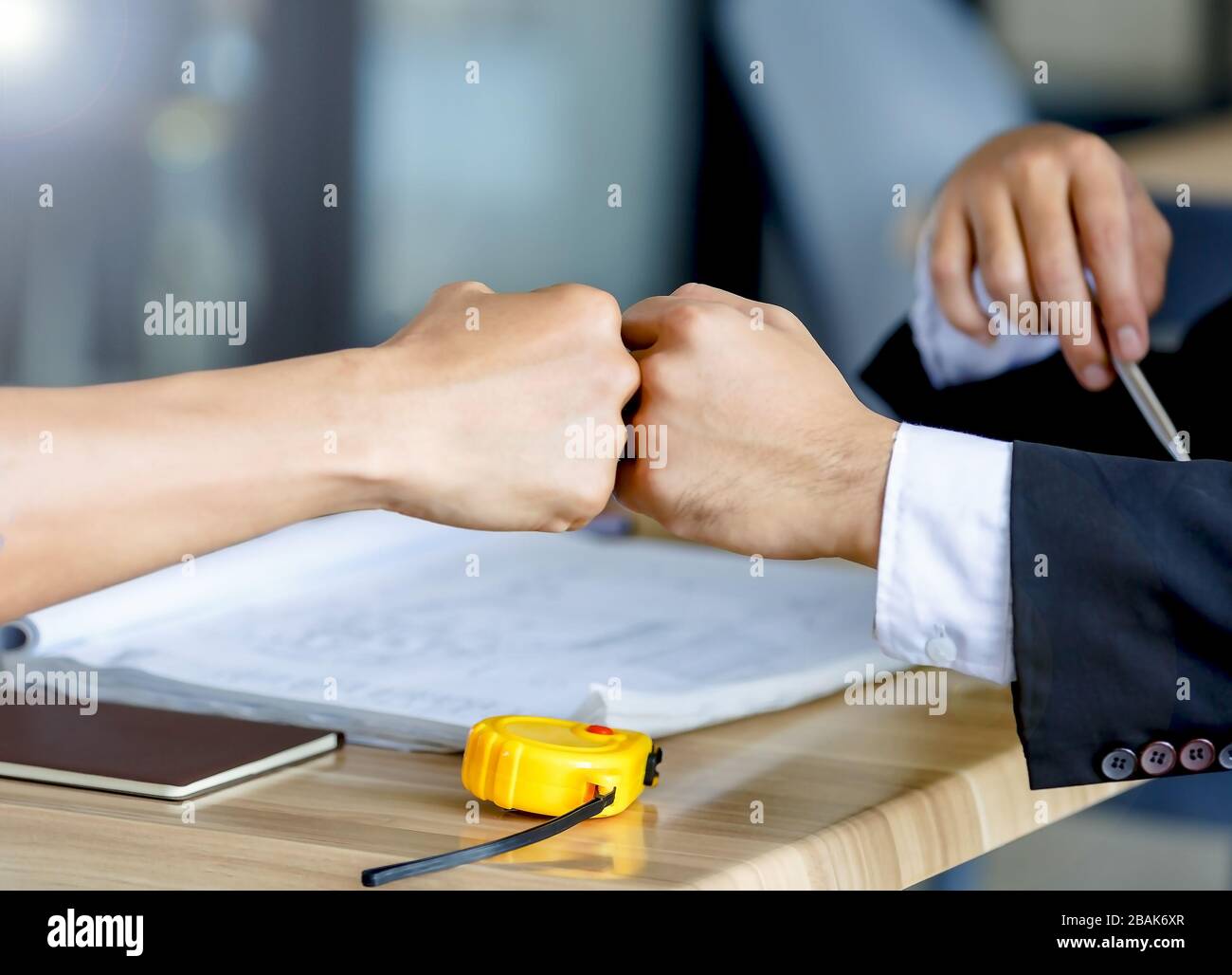 Two business partners giving each other fist bump after successful ...