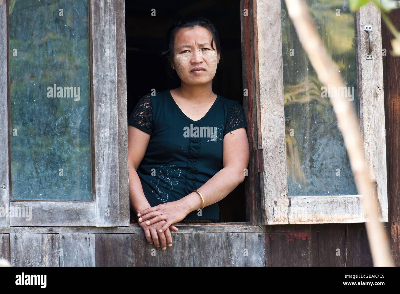 A portrait of a Burmese woman with traditional thanaka powder on the ...