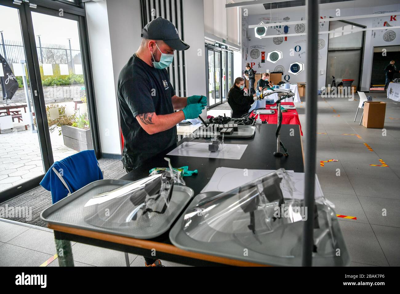 A Royal Mint employee makes a full face visor where workers, who ...