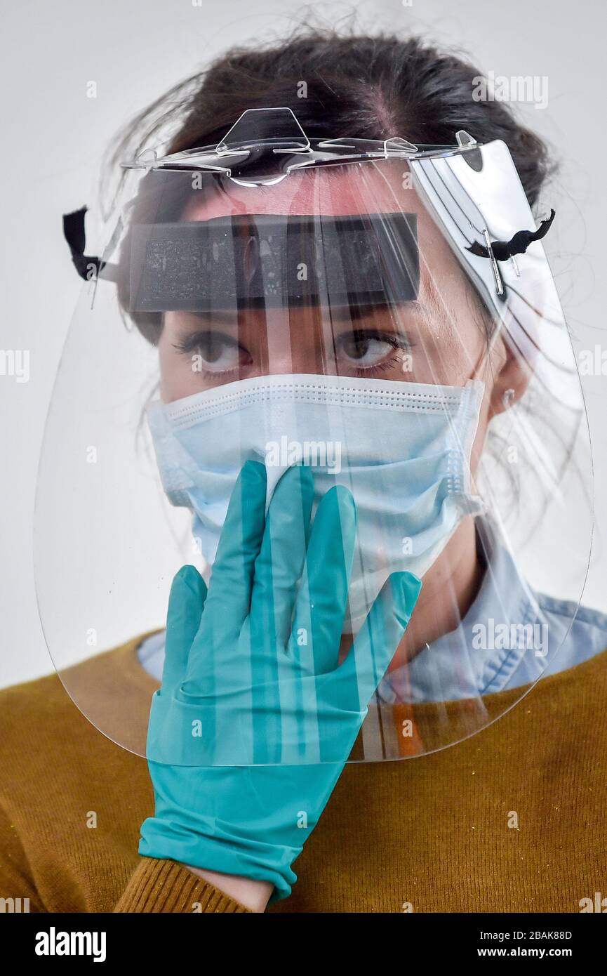 A Royal Mint employee checks the fit of a full face visor where workers ...