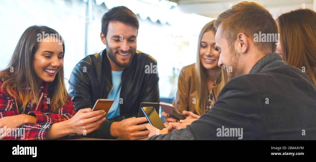 Group of friends hanging out with each other sitting in a bar using ...