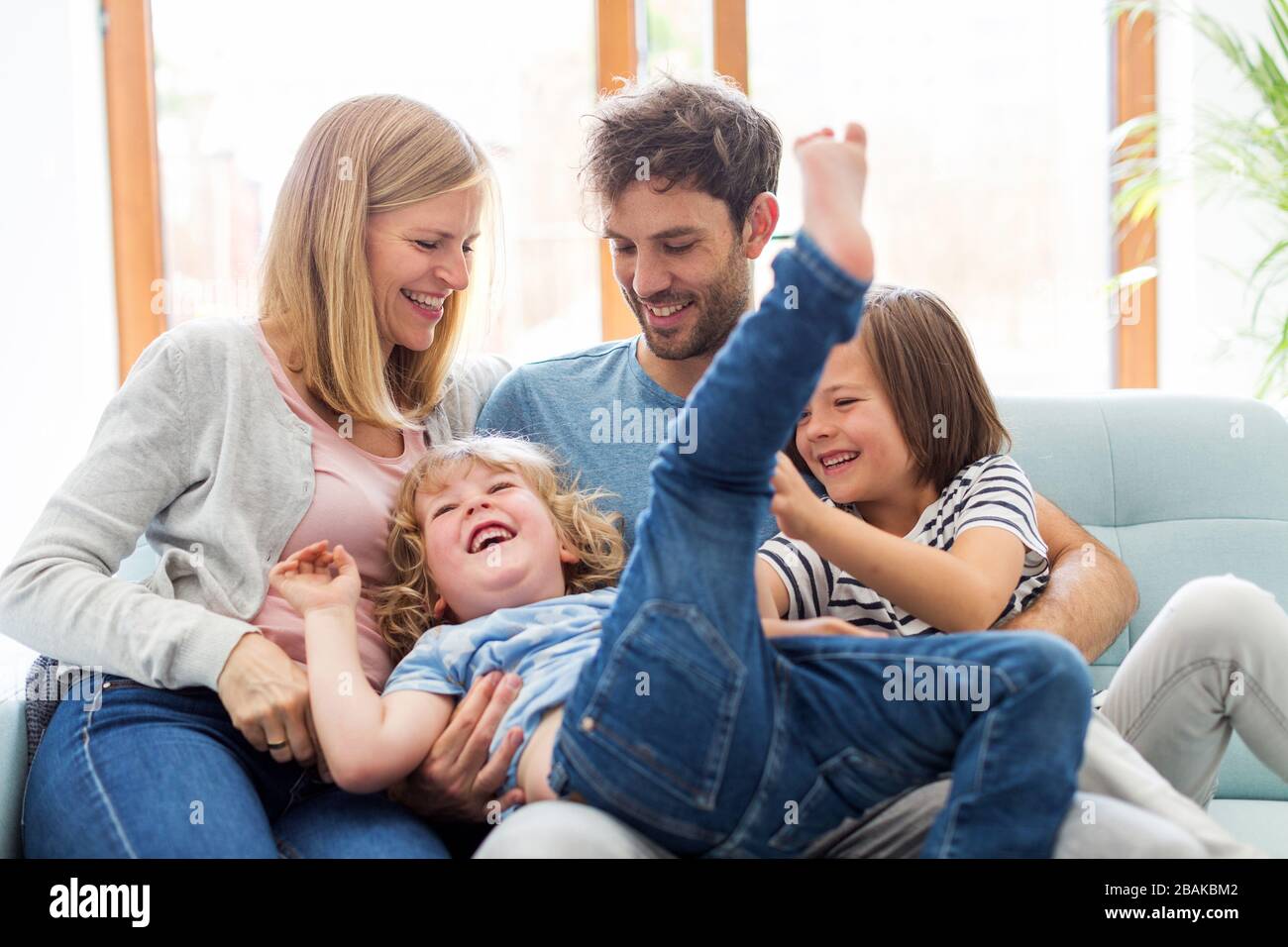 Happy young family with two children at home Stock Photo - Alamy