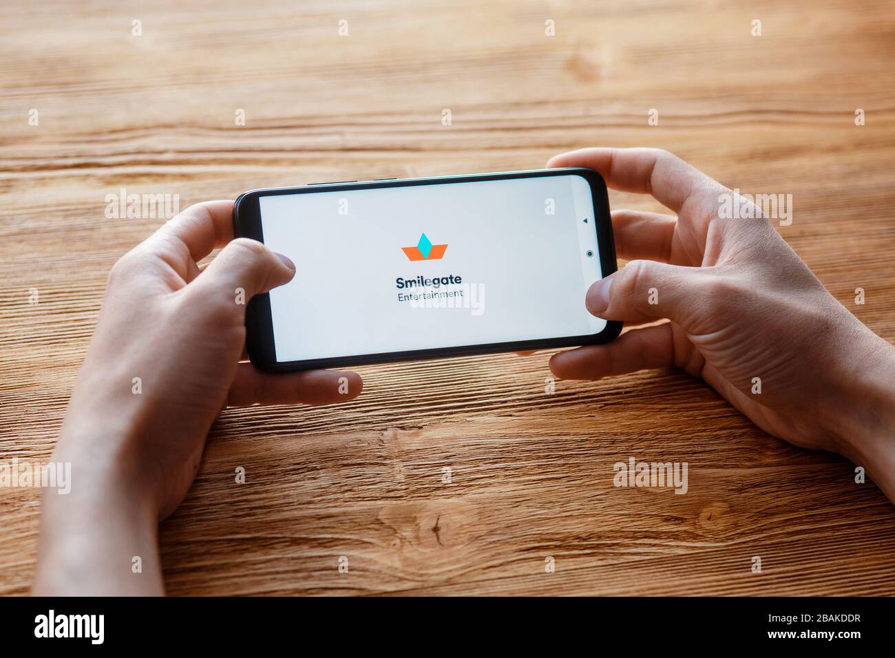 a young guy plays crossfire legend mobile game on the phone. Smartphone ...