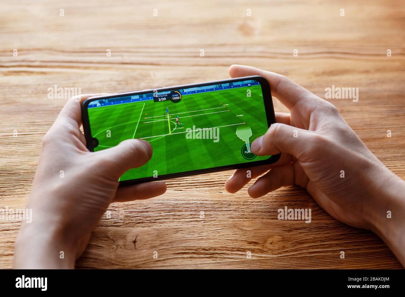 a young guy plays the fifa mobile game on the phone. Smartphone closeup ...