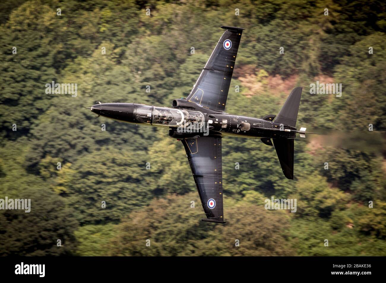 Royal Air Force (RAF) Hawk training jet from RAF Valley fling low and fast through a valley in ...