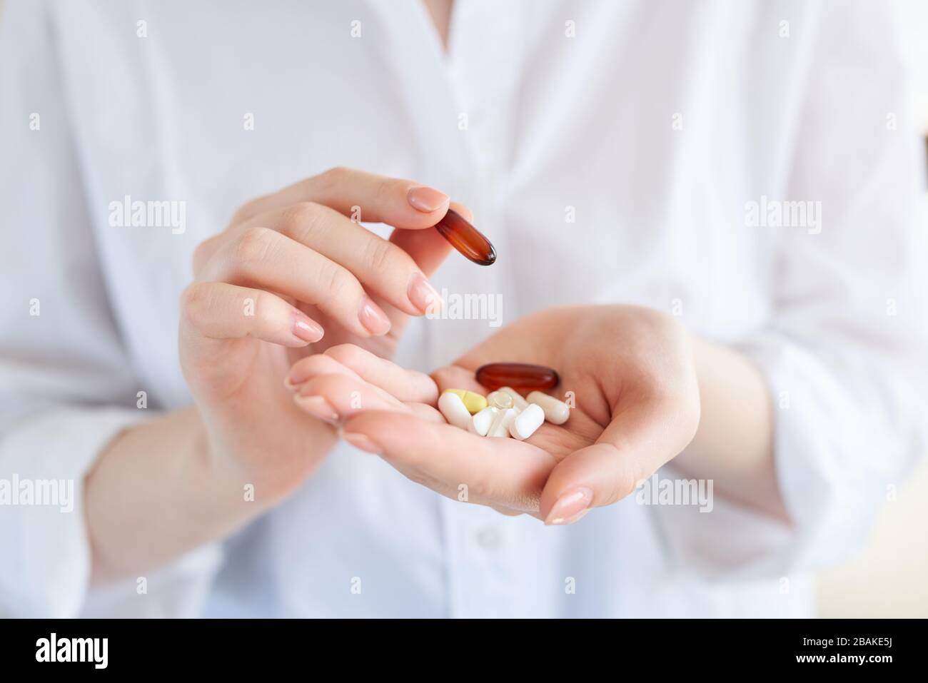 Vitamins And Supplements. Closeup of hand holding variety of white ...