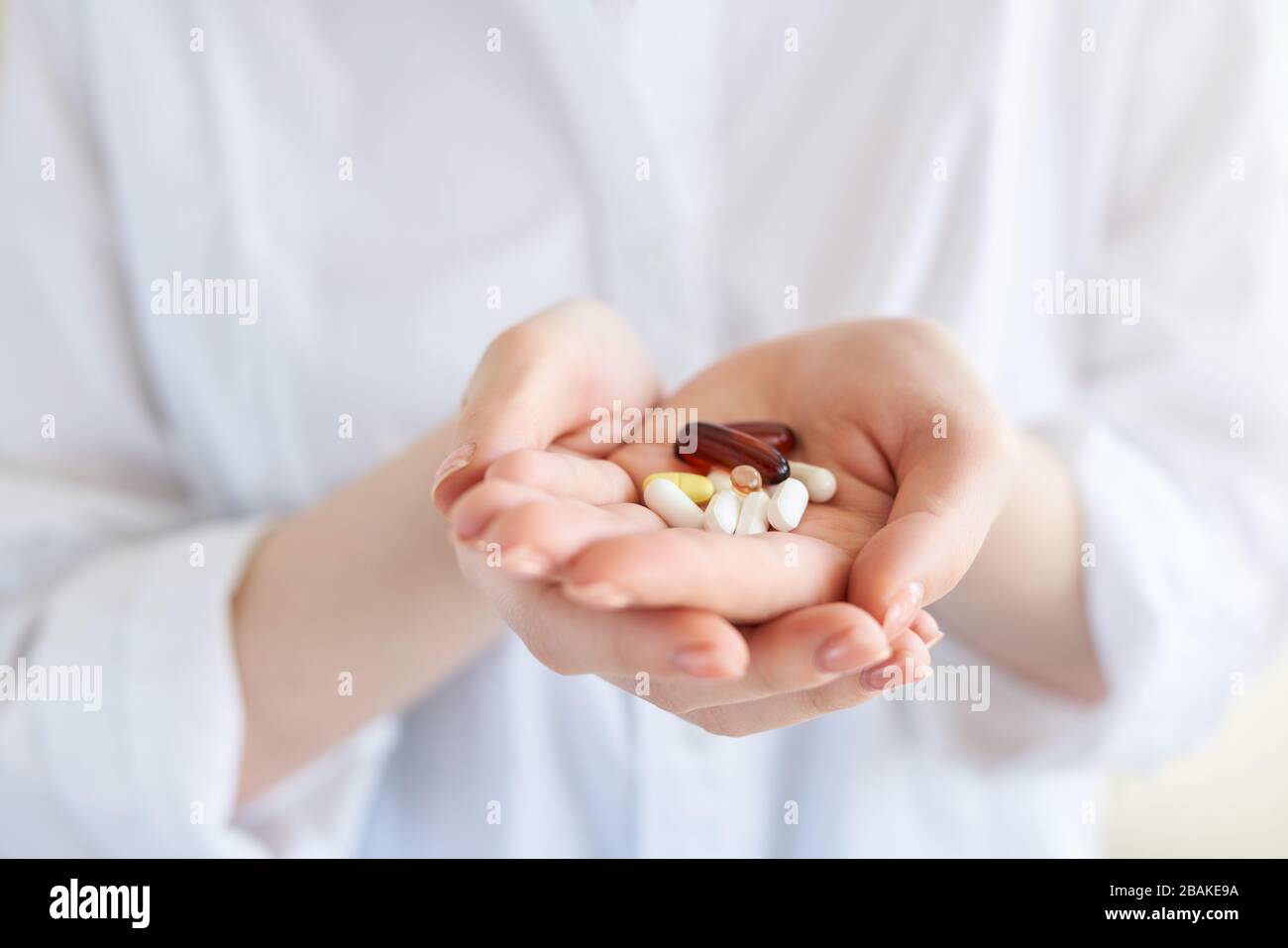 Vitamins And Supplements. Closeup of hand holding variety of white ...