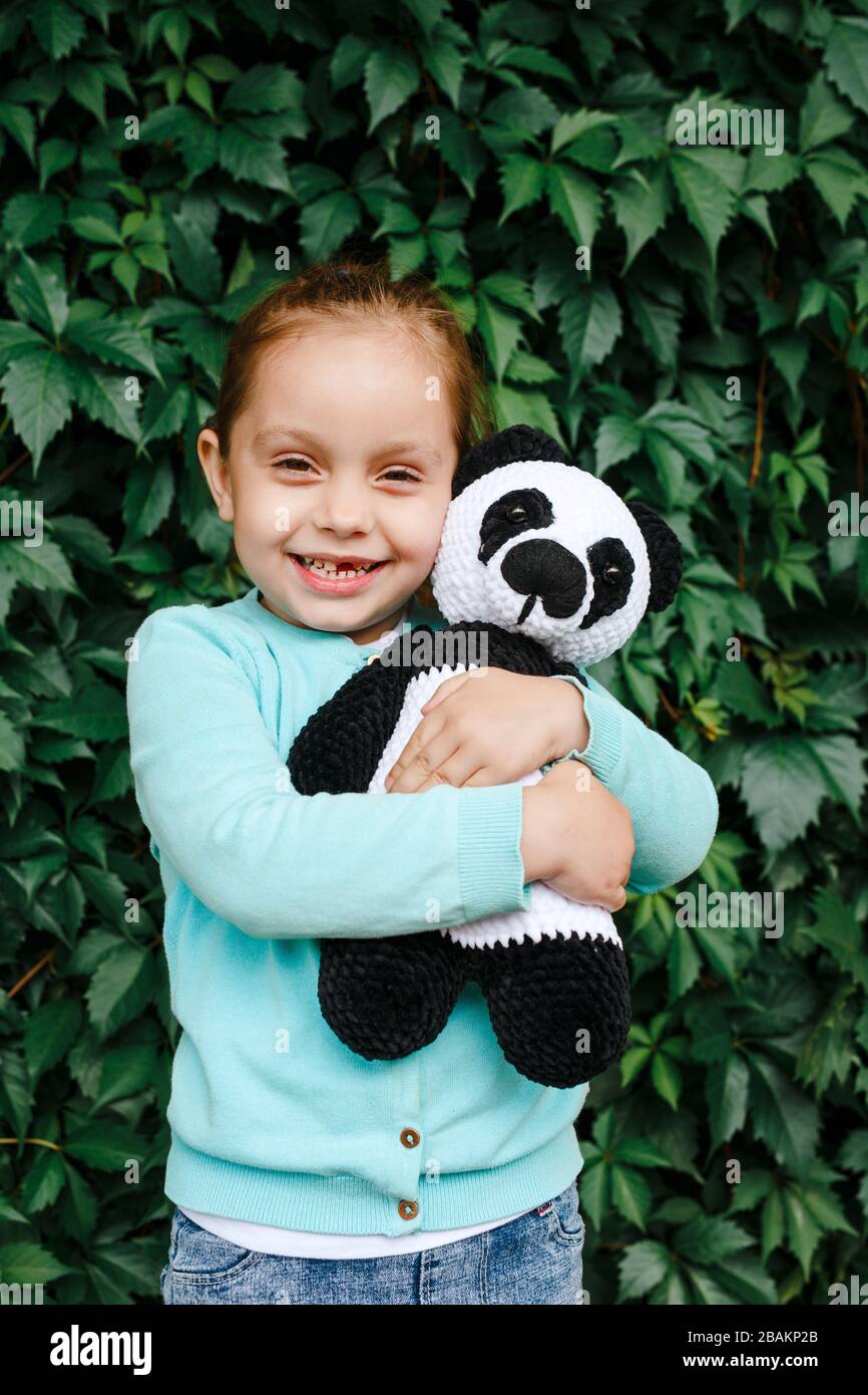 beautiful child hugging plush panda and smiling at camera Stock Photo ...