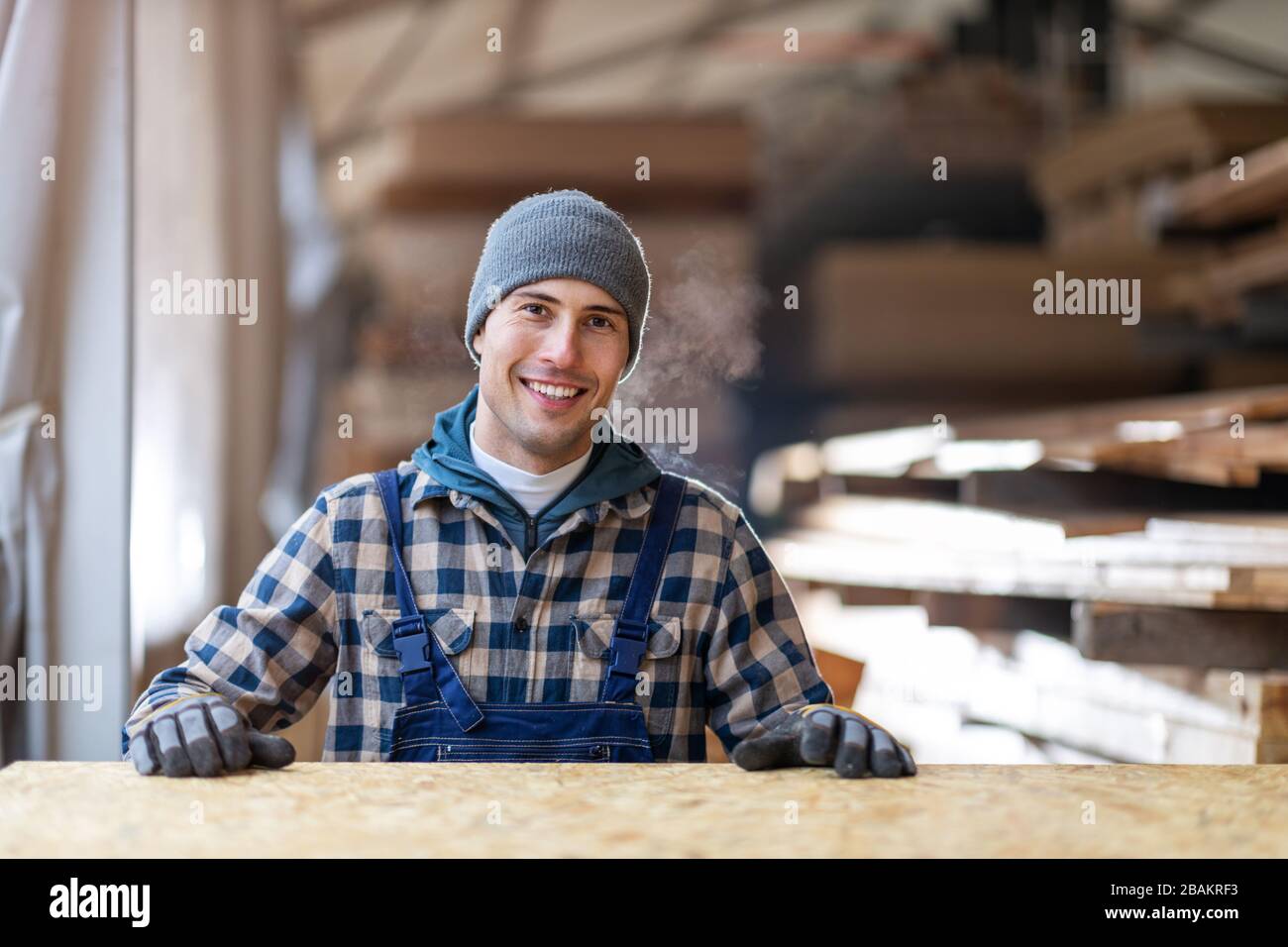 Young male worker in timber warehouse Stock Photo - Alamy