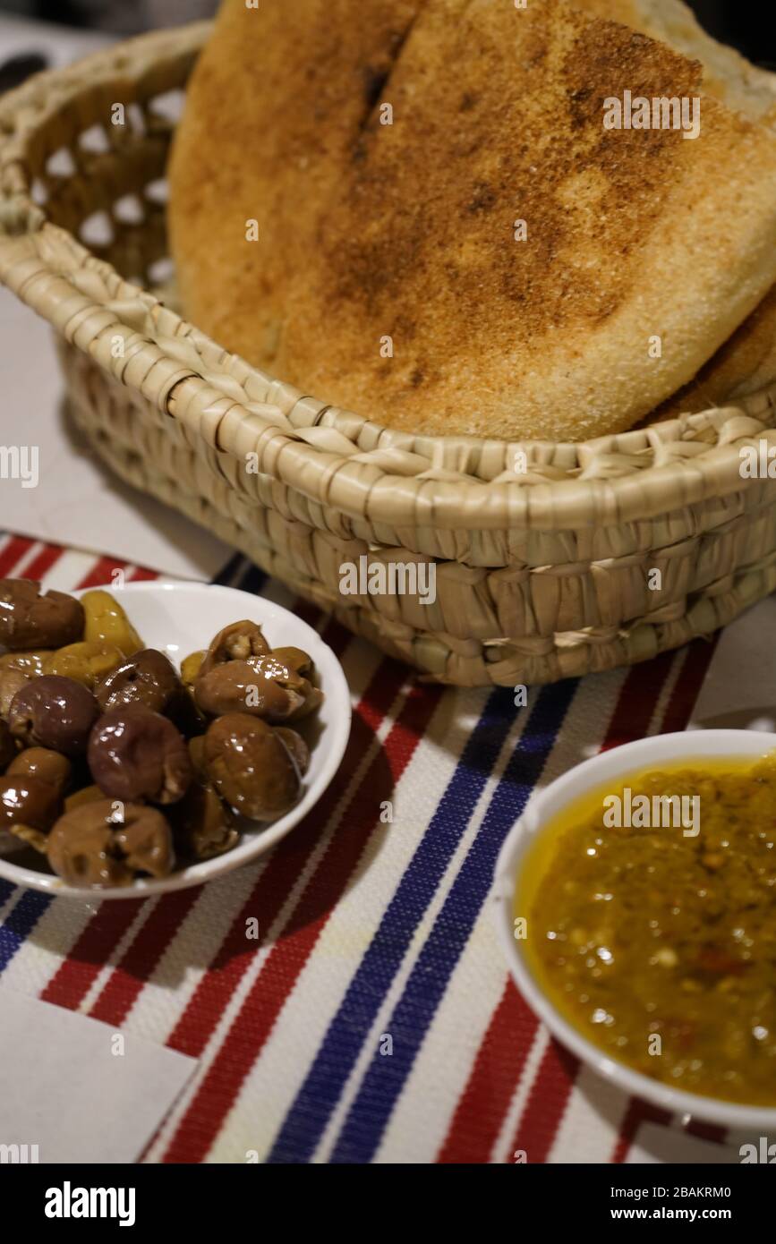 Traditional Arabic bread, olives with spices and green pepper sauceThe ...