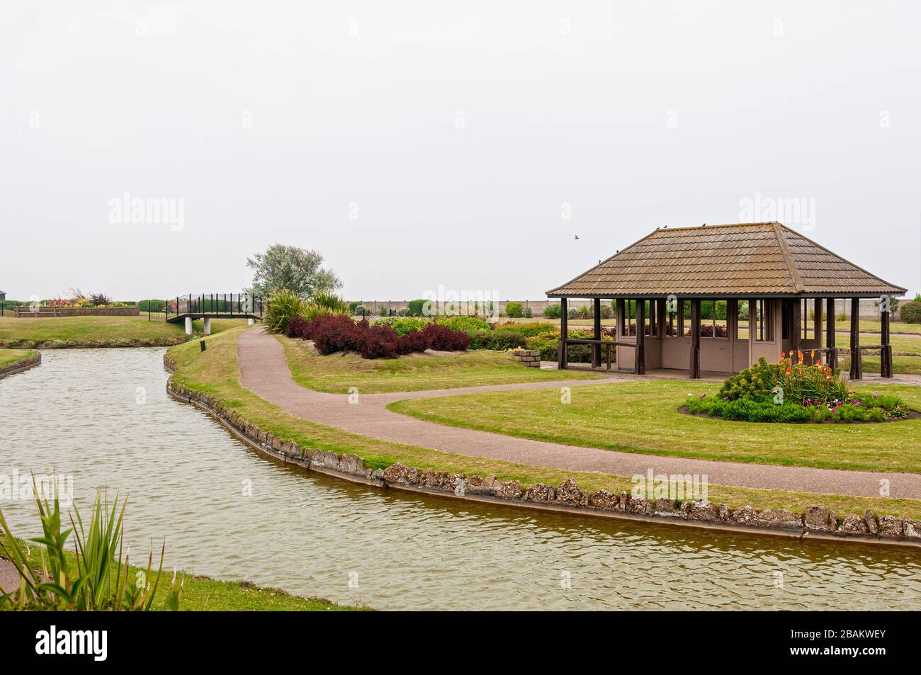 A serpentine channel lined with artificial rocks flows past an island ...