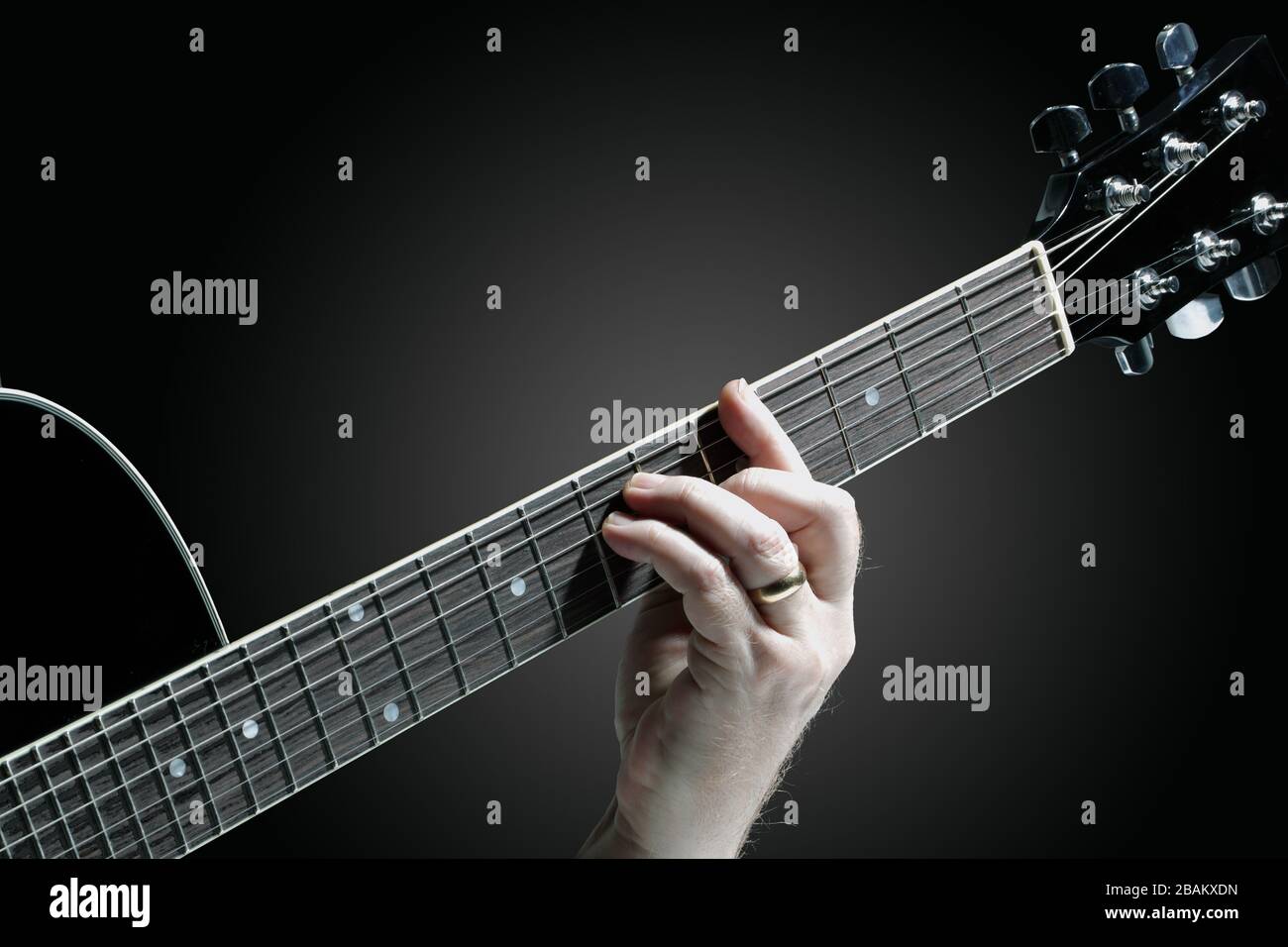 Musician playing guitar on a dark graduated background Stock Photo - Alamy