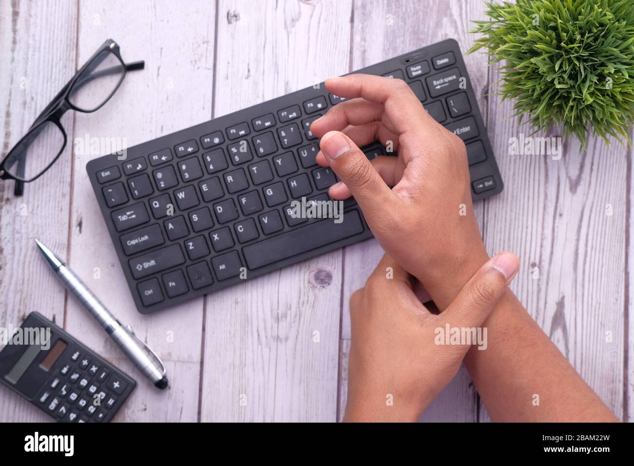 man holding her wrist pain from using computer. Office syndrome Stock ...