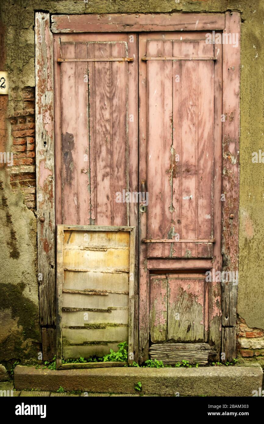 crumbling wooden door isolated on an old wall Stock Photo - Alamy