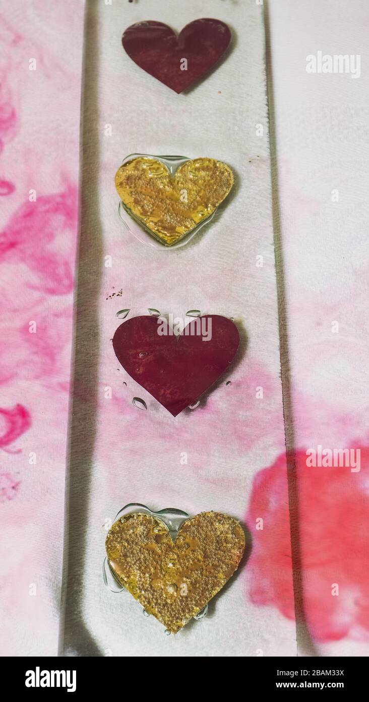 Abstract image of four small hearts set in glass with abstract art ...