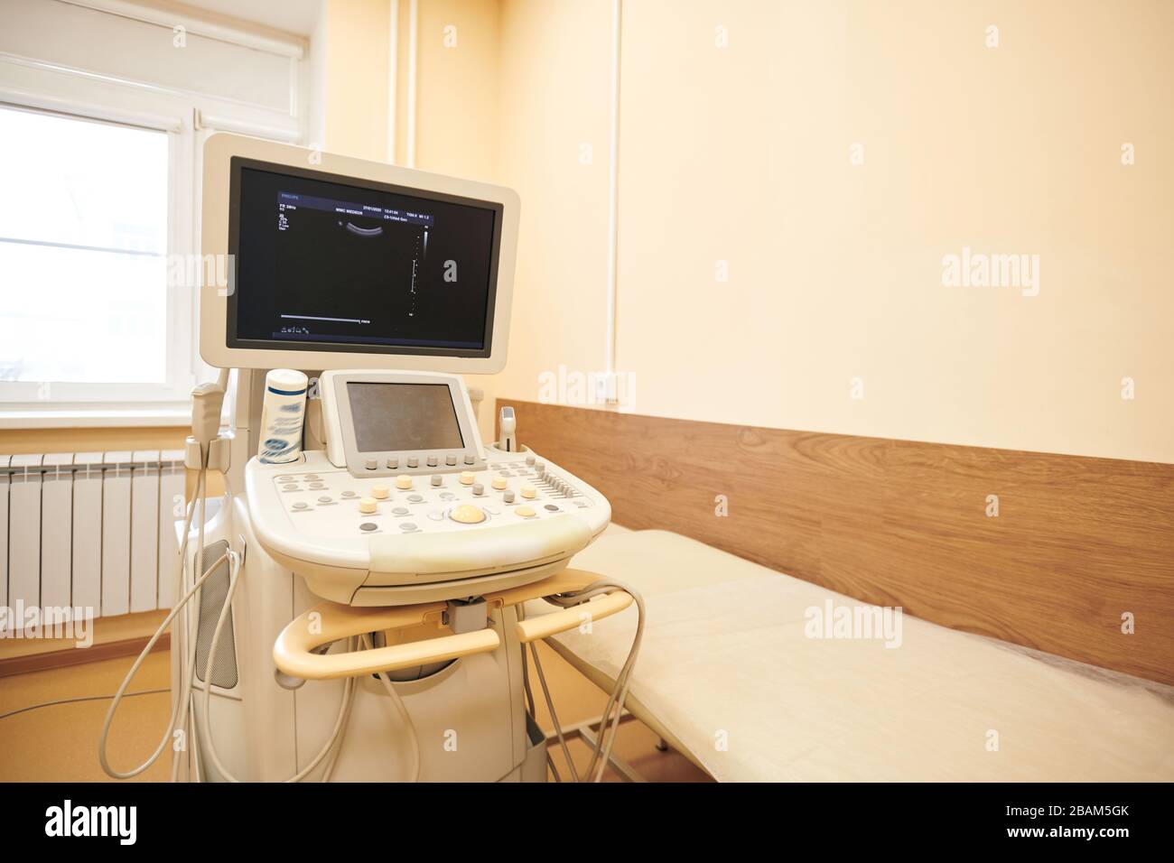 Sonographers workplace with hospital bed and ultrasound machine in ...