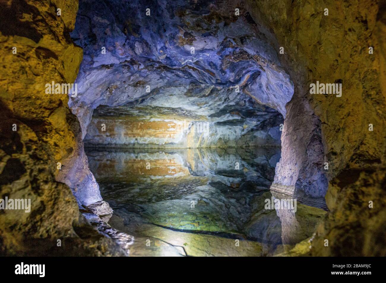 A cave with colorful walls and a tank full of water Stock Photo - Alamy