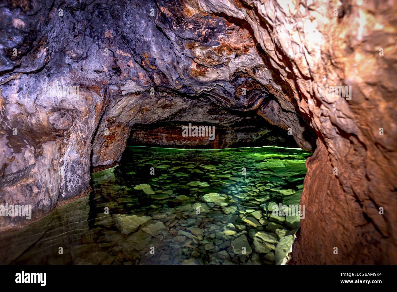 A cave with colorful walls and a tank full of water Stock Photo - Alamy