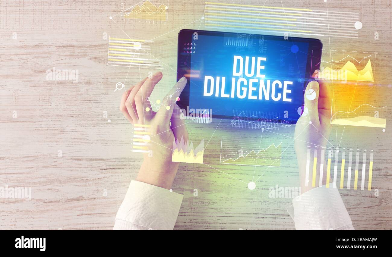 Close-up of hands holding tablet with DUE DILIGENCE inscription, modern business concept Stock ...