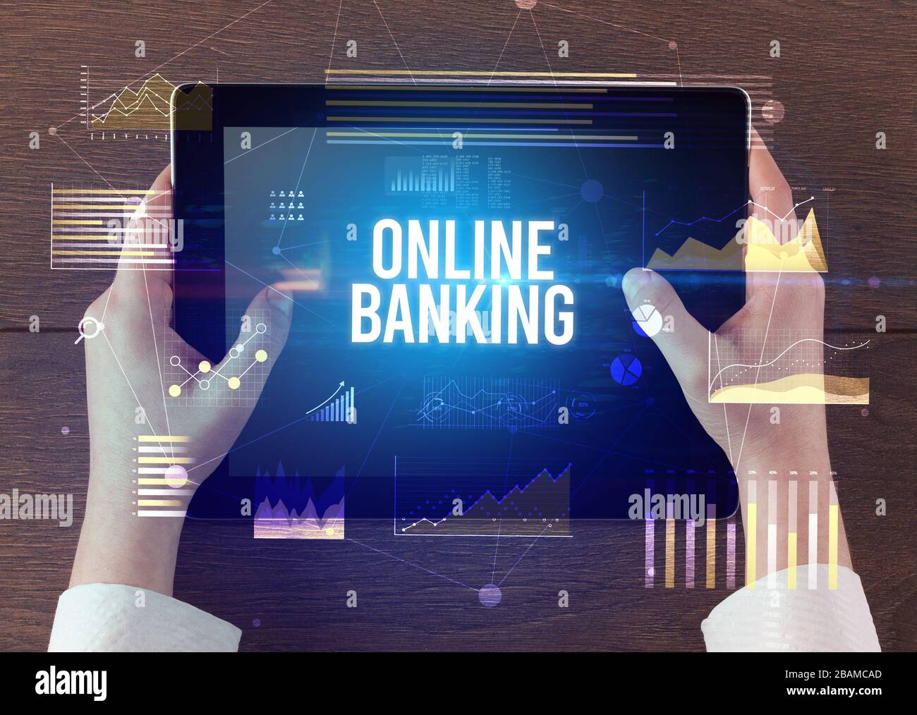 Close-up of hands holding tablet with ONLINE BANKING inscription ...
