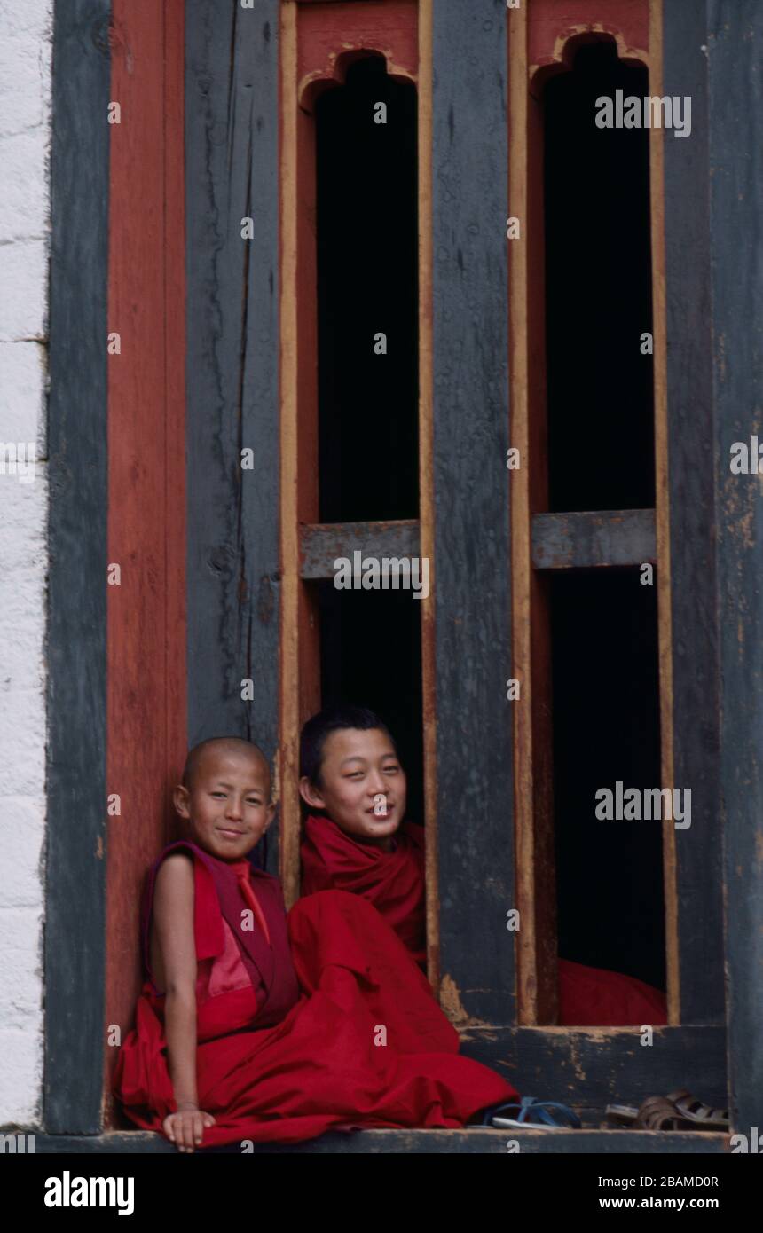Two young monk novitiates find good vantage in a window sill to observe ...