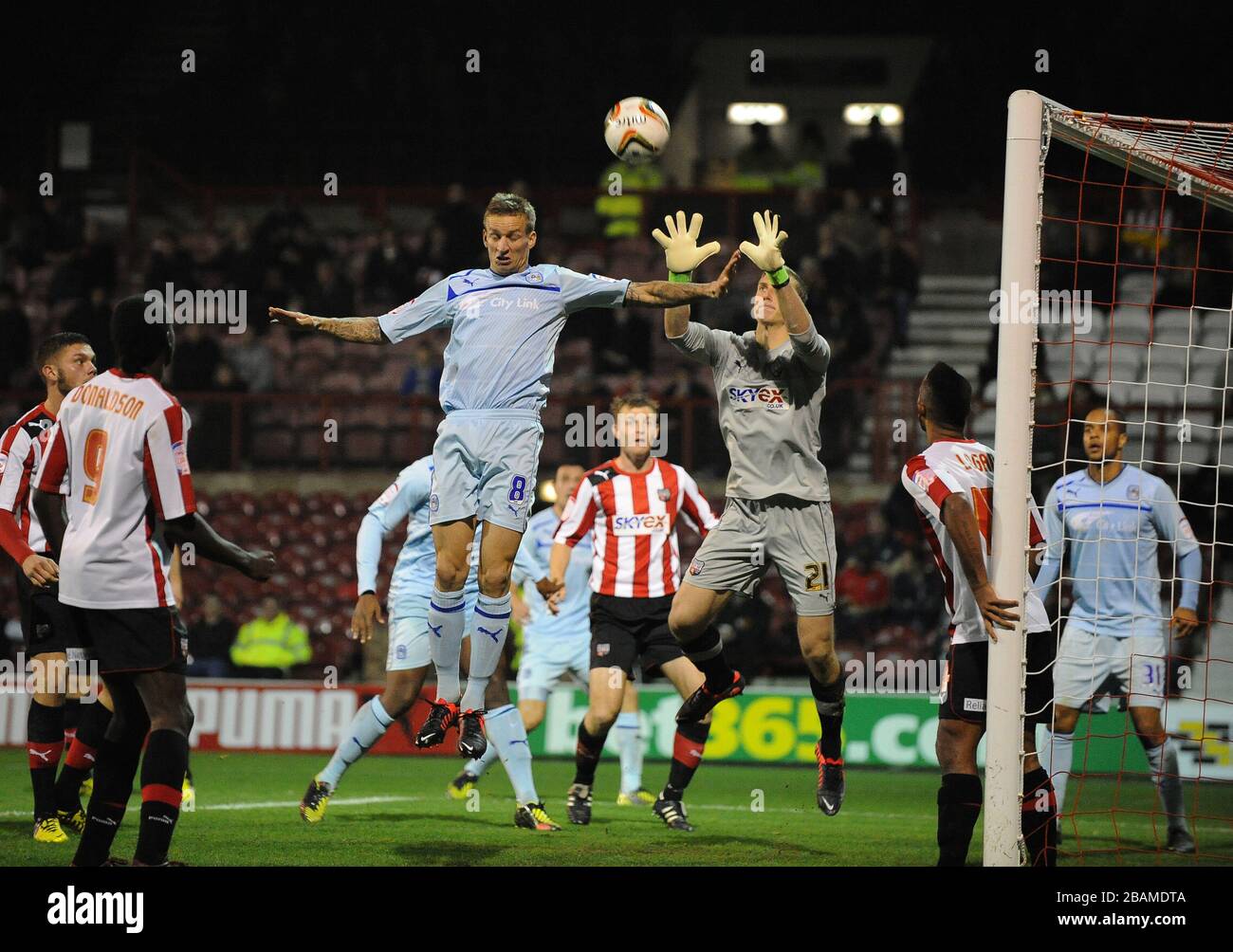 Brentford's goalkeeper Simon Moore saves from Coventry City's Carl ...