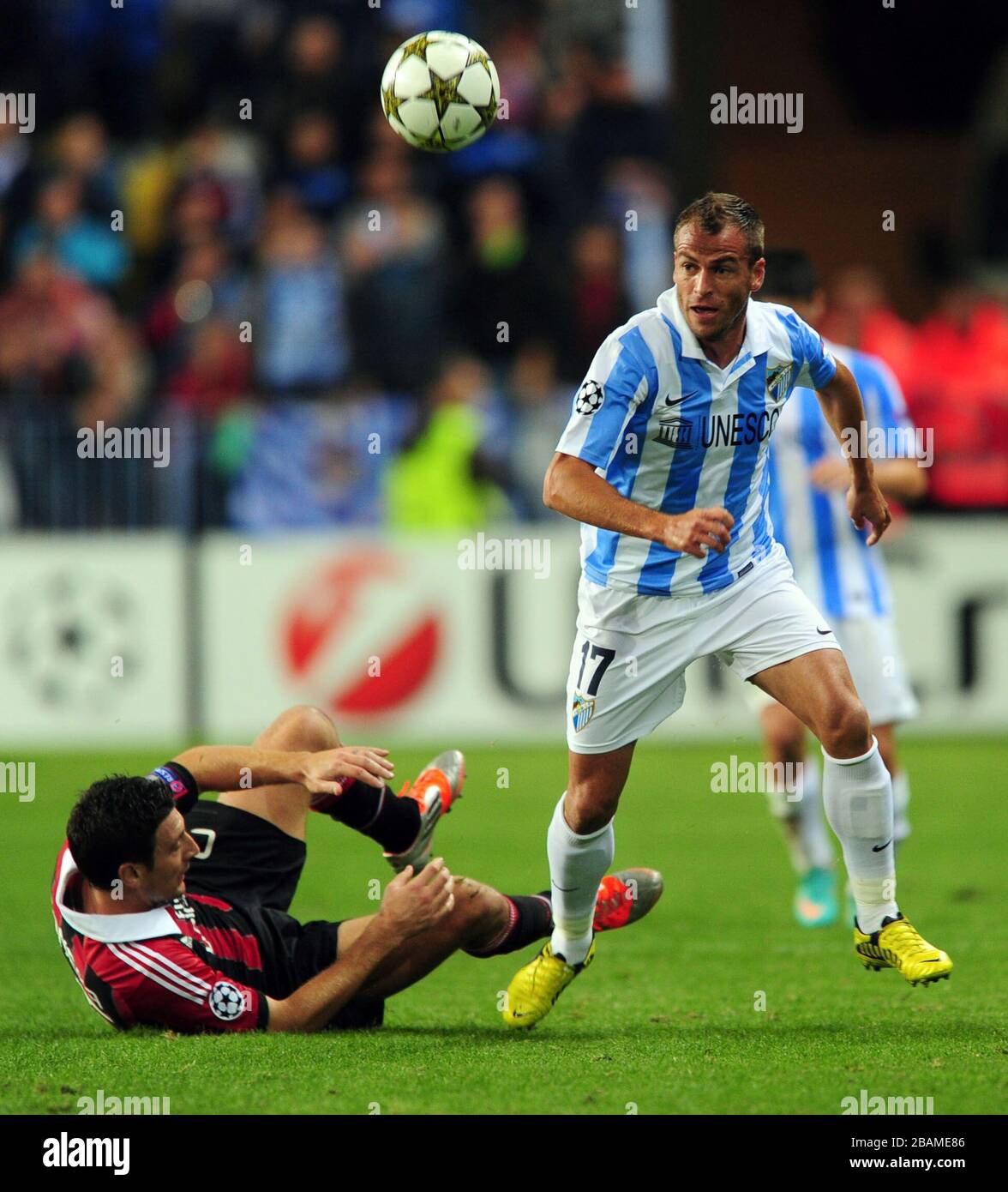 Malaga's Duda (right) skips away from AC Milan's Daniele Bonera Stock ...