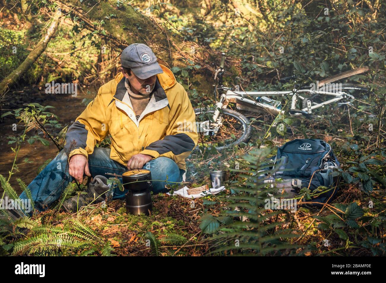 Making breakfast. Cyclist making his breakfast and practicing social ...