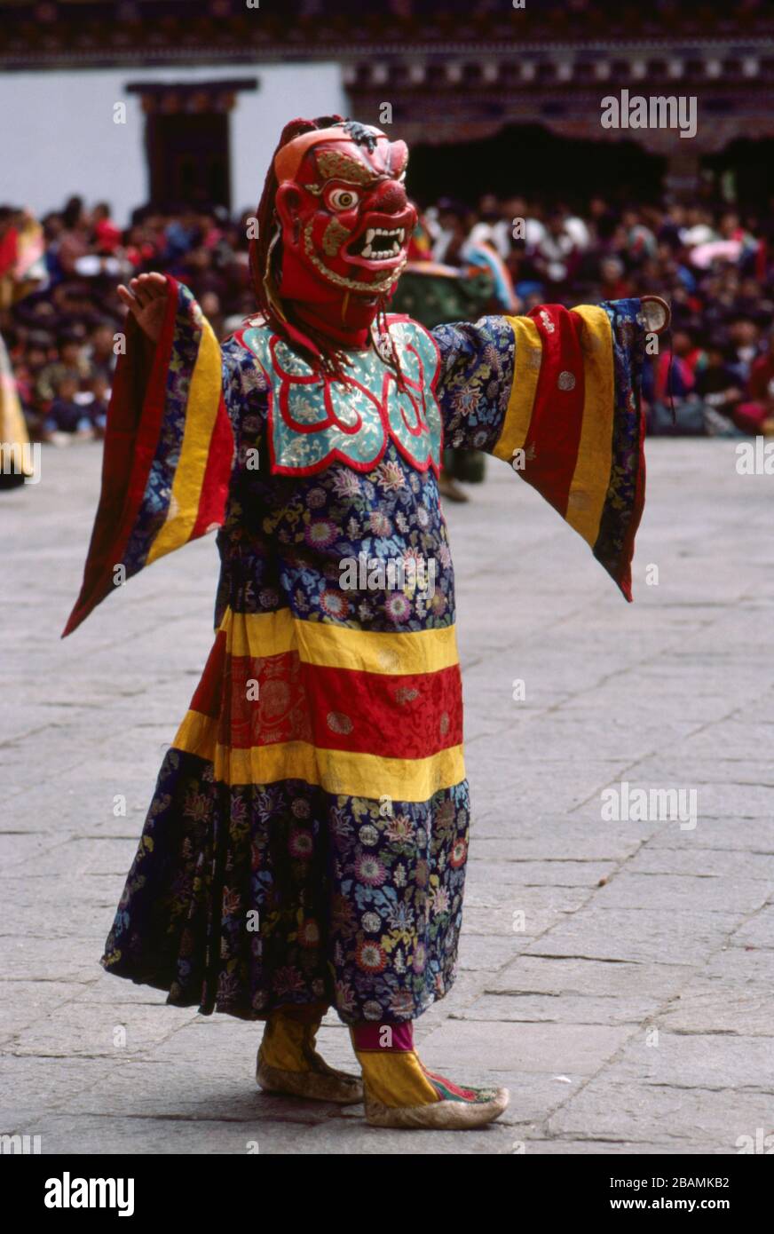 A monk dancer wearing a fearsome mask and costume parades in the dance ...
