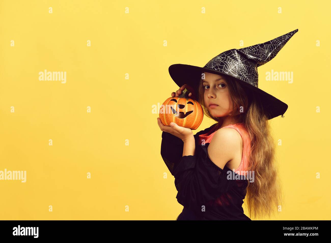 Child in witch costume and jack o lantern. Kid in black witch hat ...