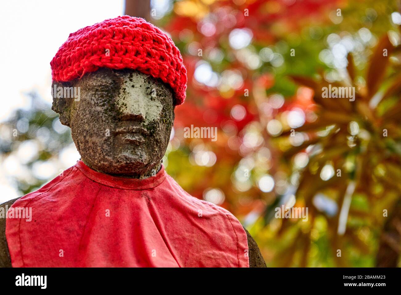 Stone sculpture dressed with red clothes Stock Photo - Alamy