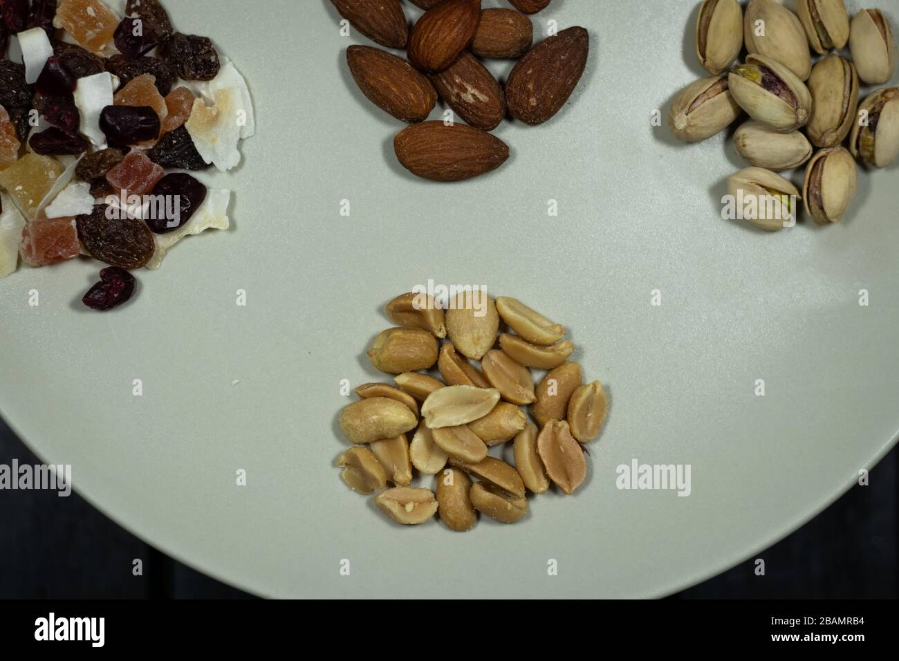Different kinds of nuts in white dish top view Almonds, Pistachios ...