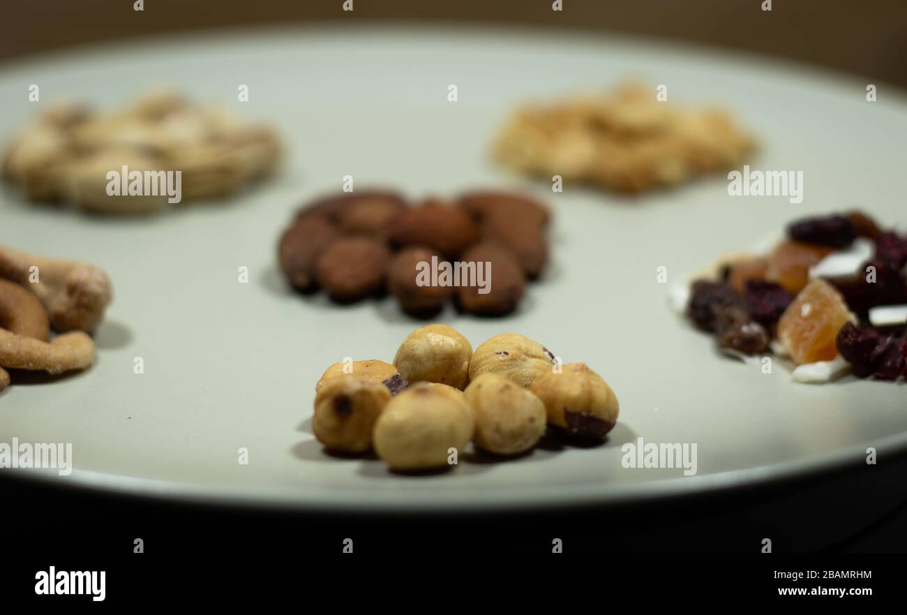Different kinds of nuts in white dish Almonds, Pistachios, Cashews ...