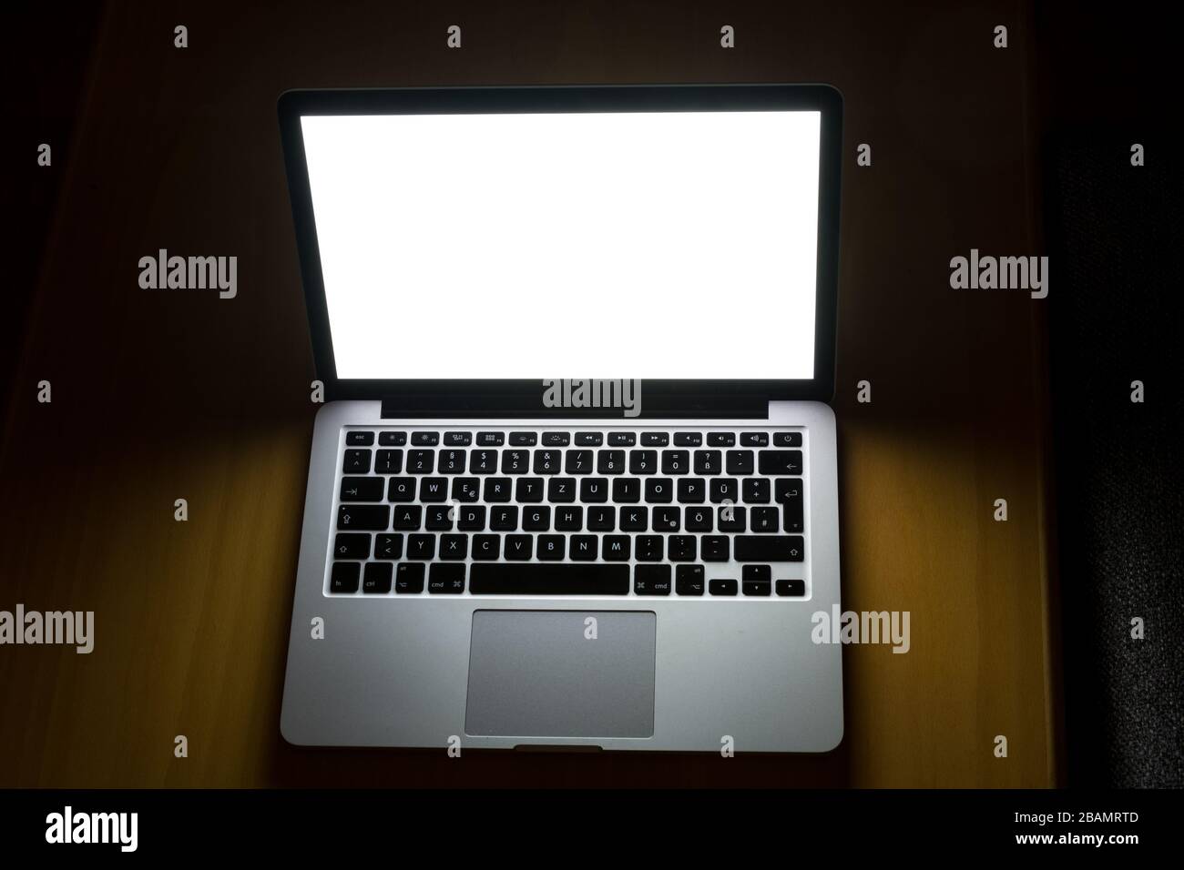 Laptop with white screen glowing in the dark at home from above Stock ...