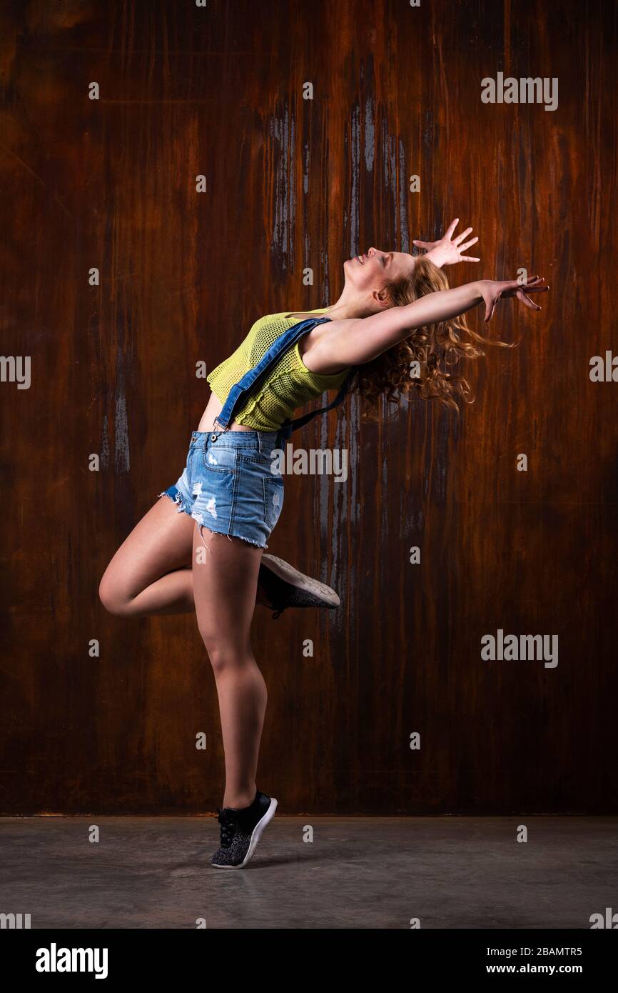 Beautiful girl in casual clothes dancing indoor at loft room with rusty ...