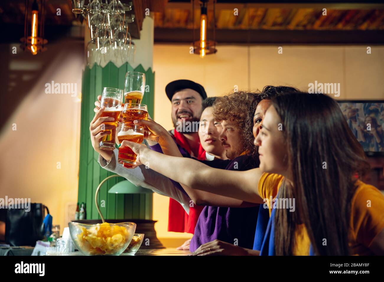 Sport fans cheering at bar, pub and drinking beer while championship ...