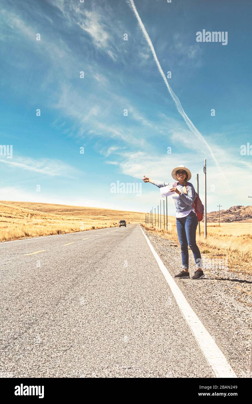 Beautiful woman hitchhiking on road in forest, hitchhiking with thumbs ...