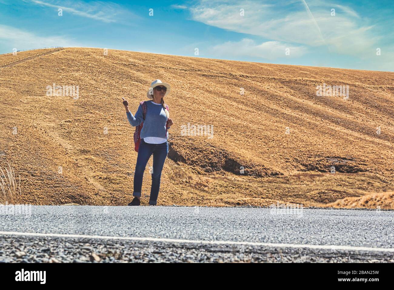 Beautiful woman hitchhiking on road in forest, hitchhiking with thumbs ...