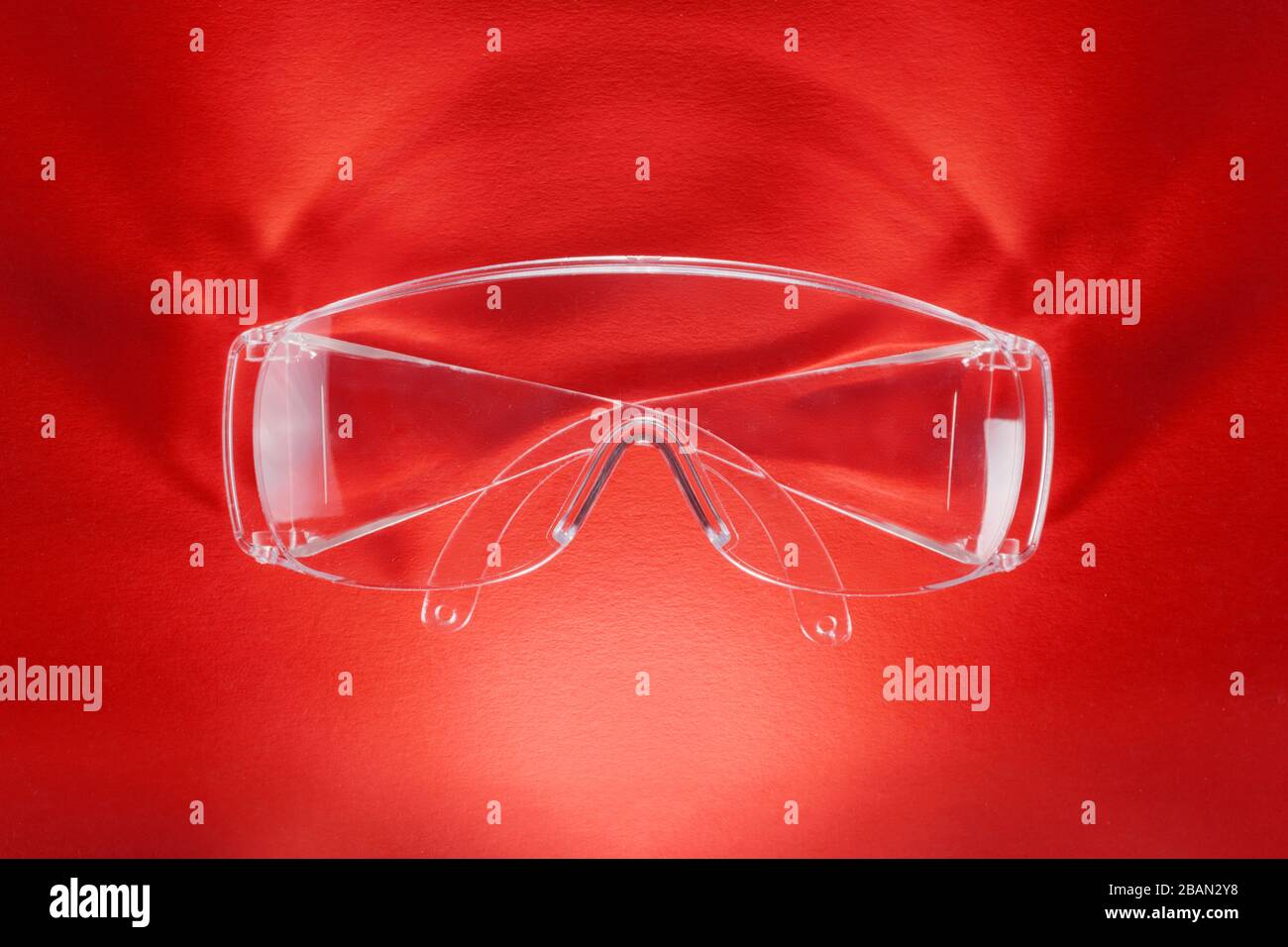 Transparent safety glasses on red background. Front view Stock Photo ...