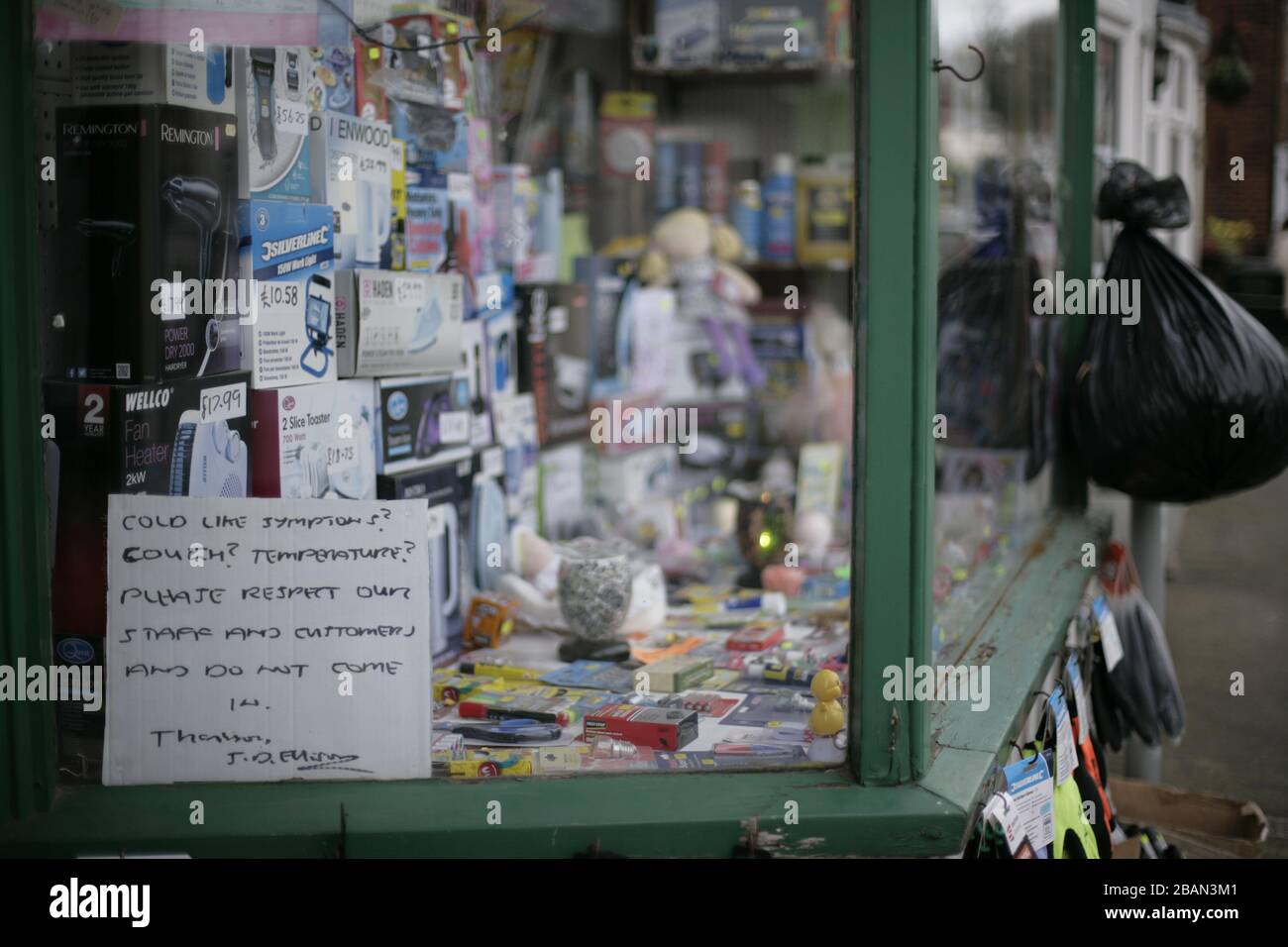 Coronavirus symptoms restrictive warning sign on hardware shop window ...