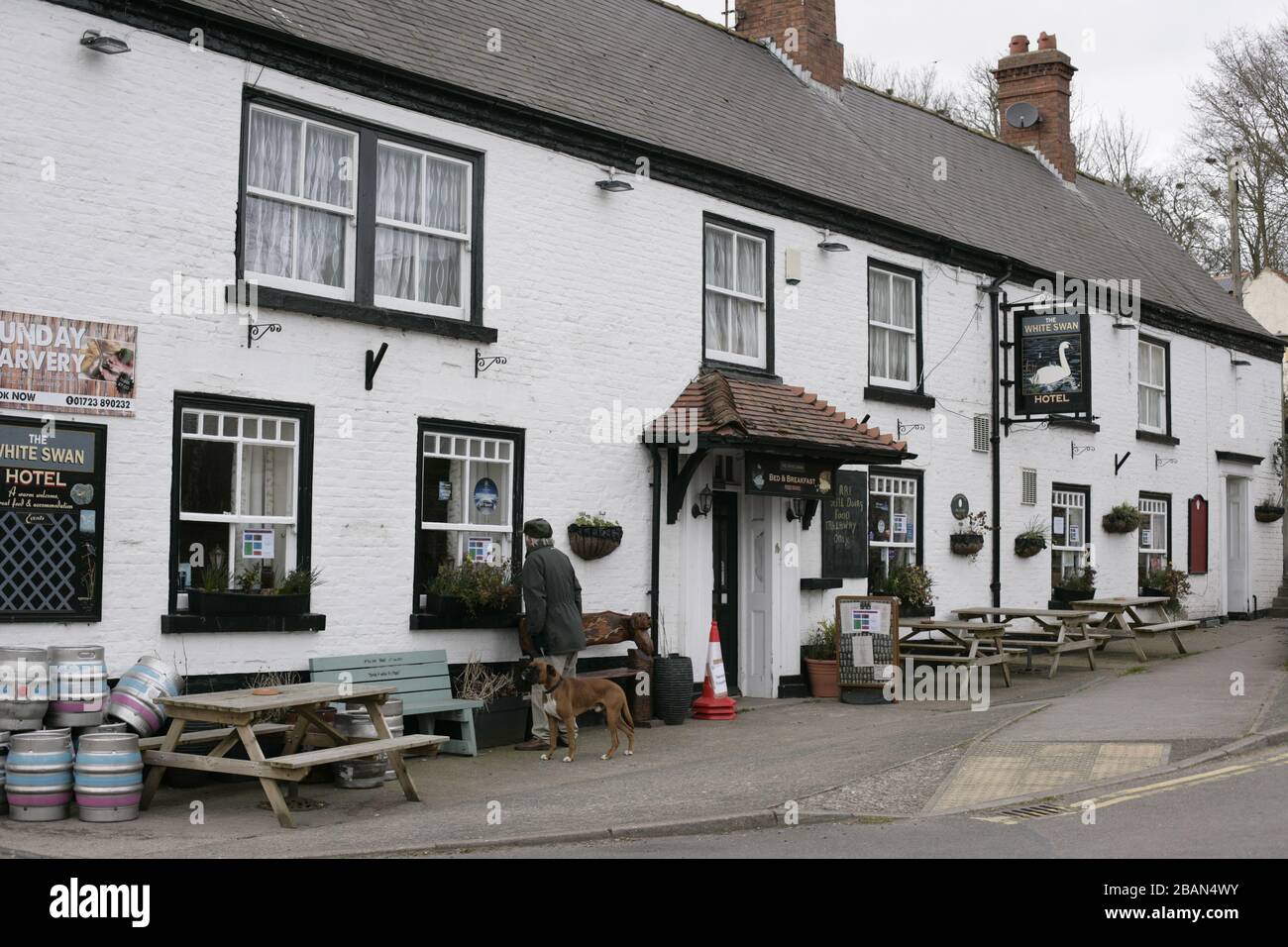 Customer reading coronavirus information sign on closed public house ...