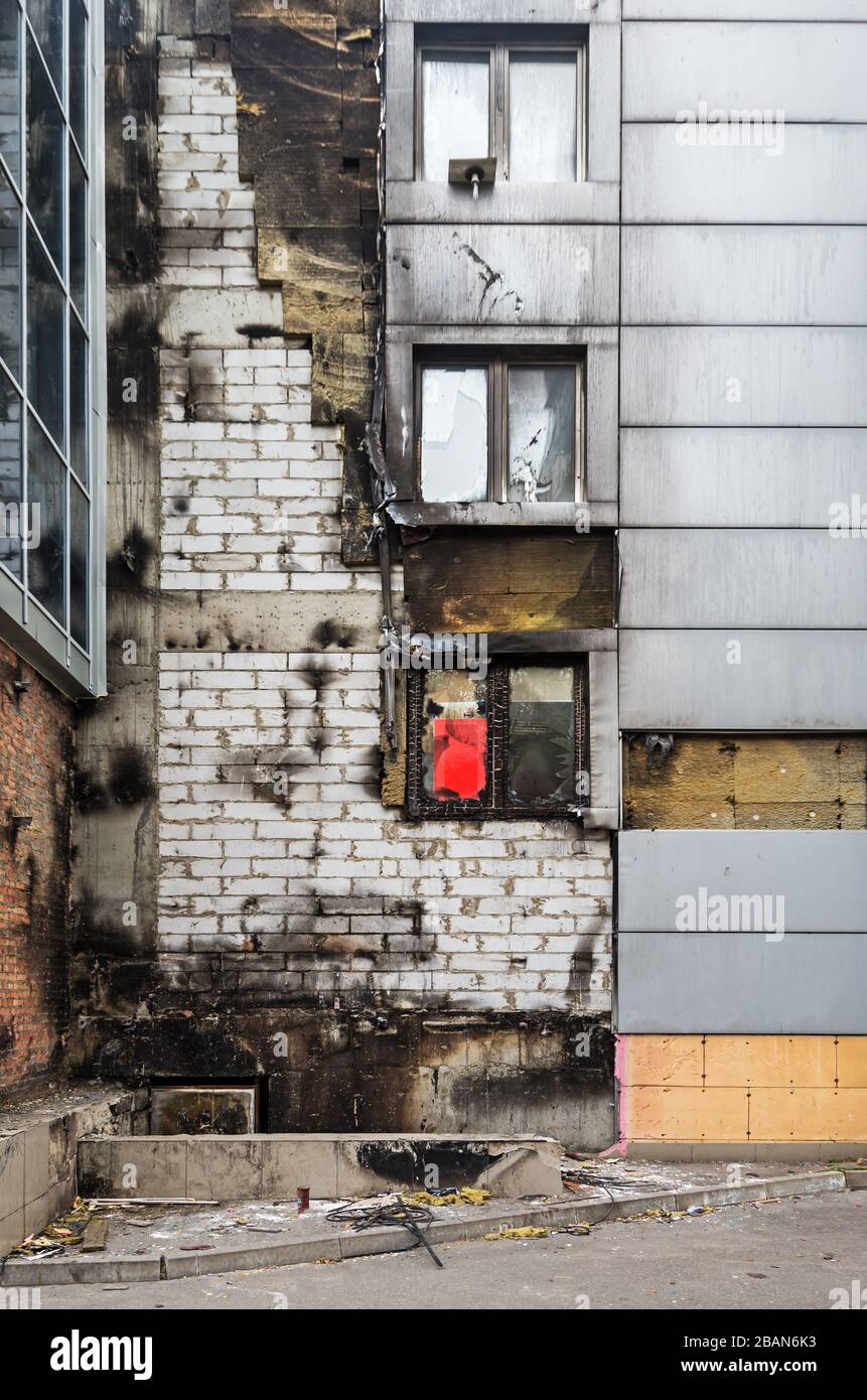 Burned-out wall of administrative building covered with plastic ...